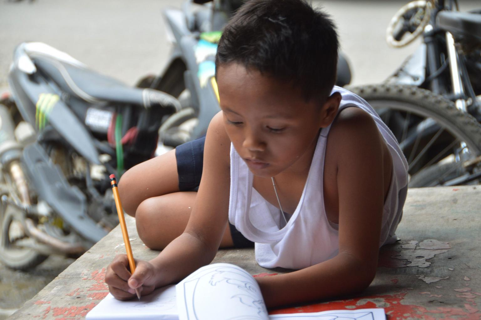 Photo of Filipino boy using light from McDonald's to do homework ...