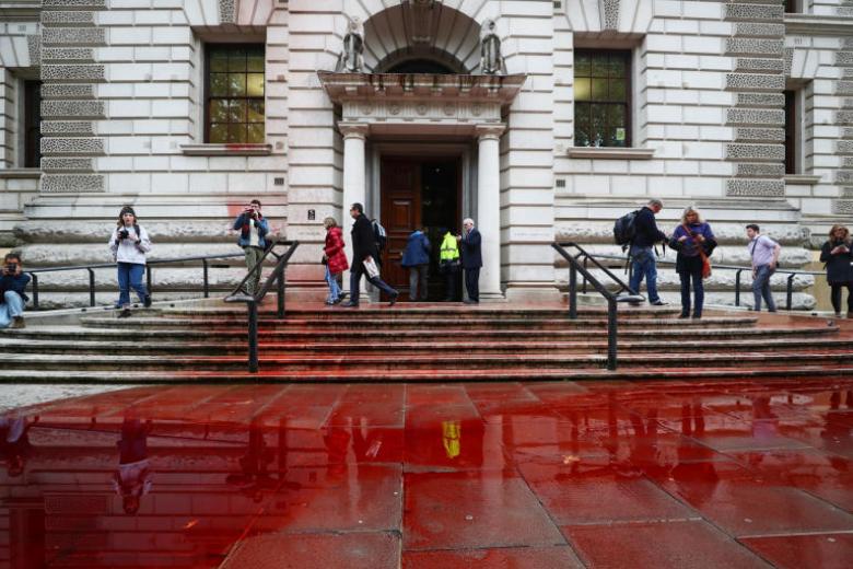 Climate change activists spray red paint at British Treasury from fire ...