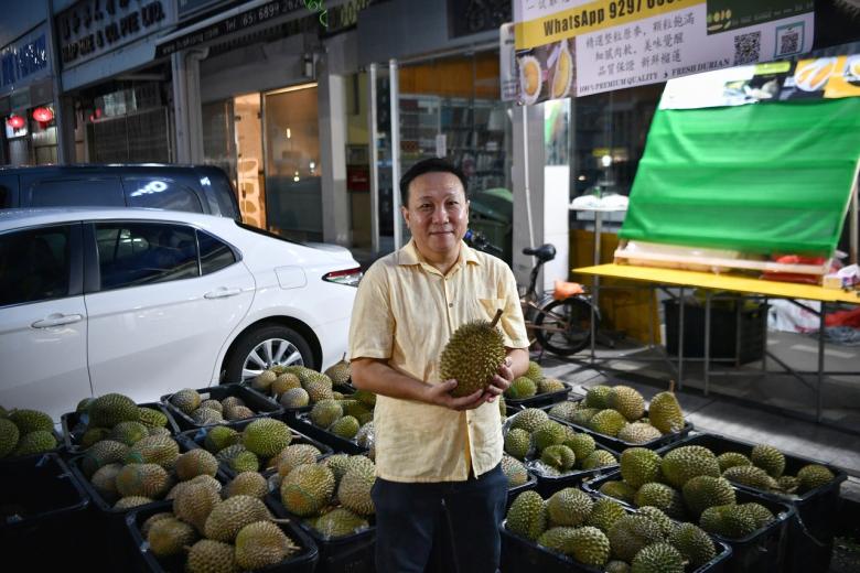 Sellers of thorny fruit in Singapore taking a bite of Malaysian durian ...