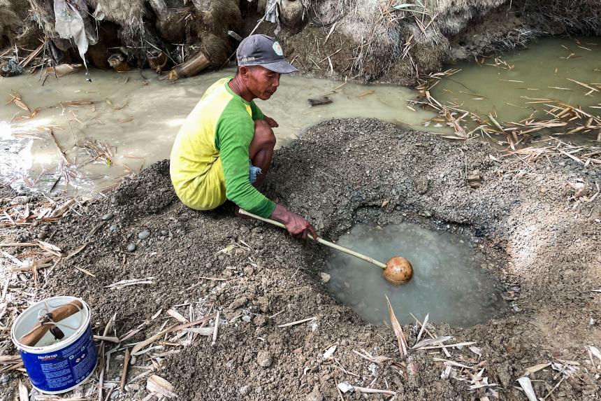 Desperate for a drink, Indonesian villagers dig up dry river bed in ...
