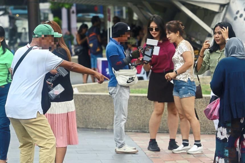 Touts around Kuala Lumpur City Centre pester tourists to have paid shots taken | The Straits Times