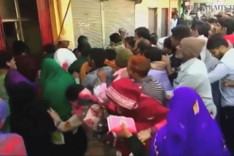 Police in India use force to push crowd away from bank | The Straits Times